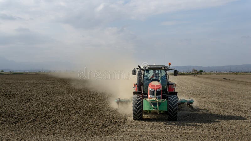 Tractor Plowing a Dusty Field in Delta Stock Photo - Image of field ...