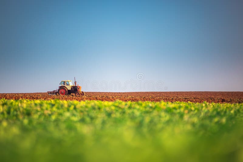Tractor plowing the fields stock photo. Image of fields - 215376604