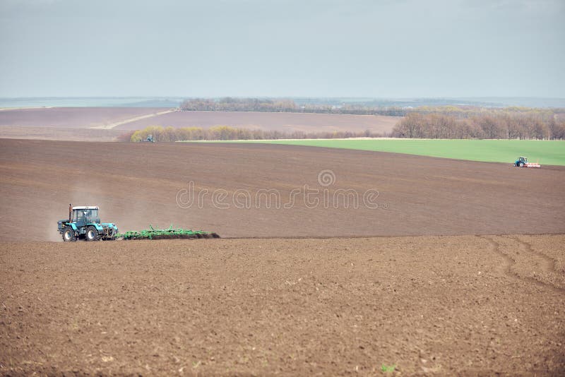 A Tractor Plowing and Sowing in the Field Stock Photo - Image of ...
