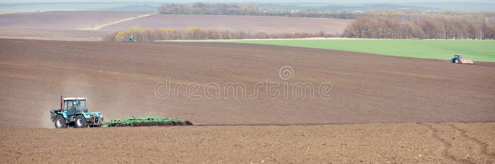 A Tractor Plowing and Sowing in the Field. Panoramic Format Stock Image ...