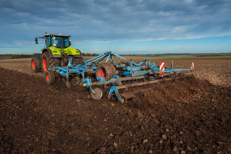 Tractor Pulling a Plow for Sowing, Beautiful Sky with Clouds Above ...