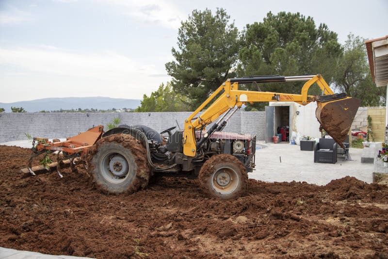 Tractor with Shovel Working on Garden Remodeling Stock Photo - Image of ...