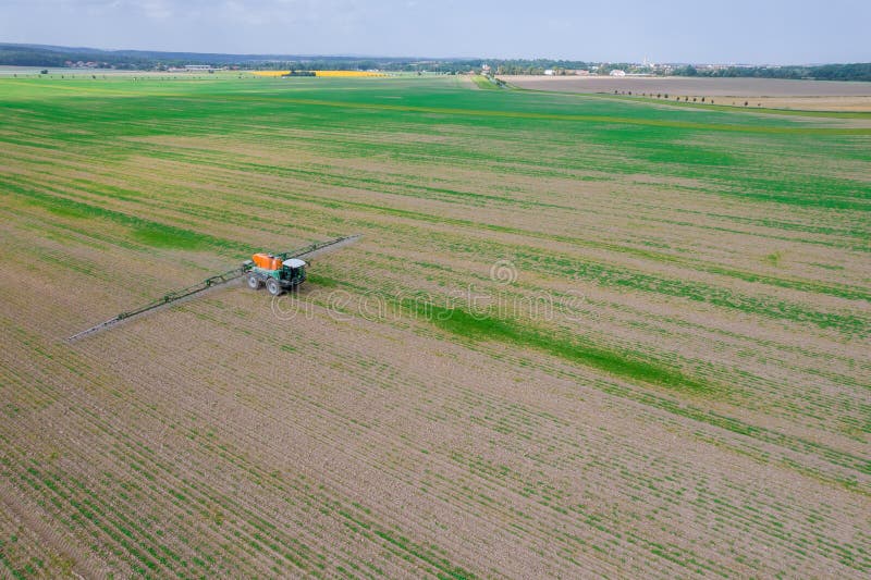 A Tractor with a Sprayer Processes the Field with Fertilizer ...