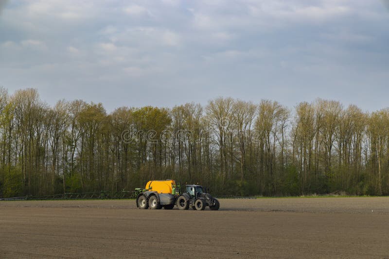 Tractor with a Sprayer during Spring Work in the Field Stock Photo ...