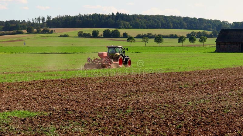 A tractor tills a field stock video. Video of farming - 301907907