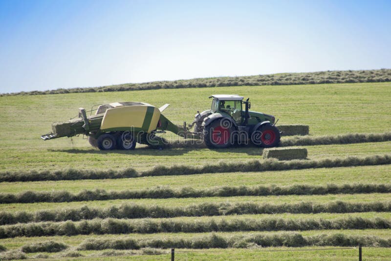 Tractor at Work in Field Loading Hay Stacks Stock Image - Image of ...