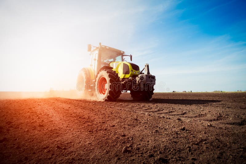 Tractor Working on Farm Land on Sunset Stock Photo - Image of ...
