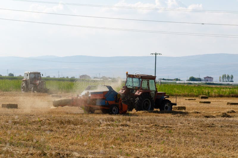 The Tractor Works on the Field on Cleaning Straw . Stock Image - Image ...