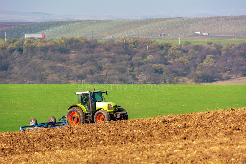 A Man Works the Land in the Garden with a Cultivator, Prepares the Soil ...