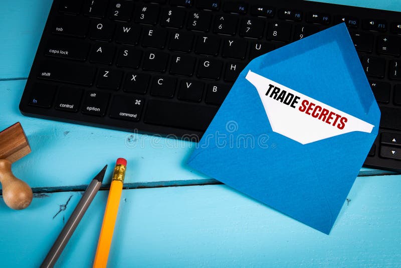 TRADE SECRETS Concept. Letter and Computer Keyboard on Blue Office Desk ...