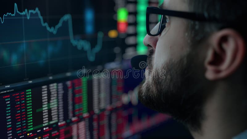 Trader is Working with Multiple Computer Screens Full of Charts and Data Analysis and Stock ...