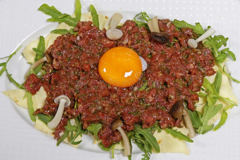 Traditional Beef Steak Tartare with Egg Yolk and Condiments in a Plate ...