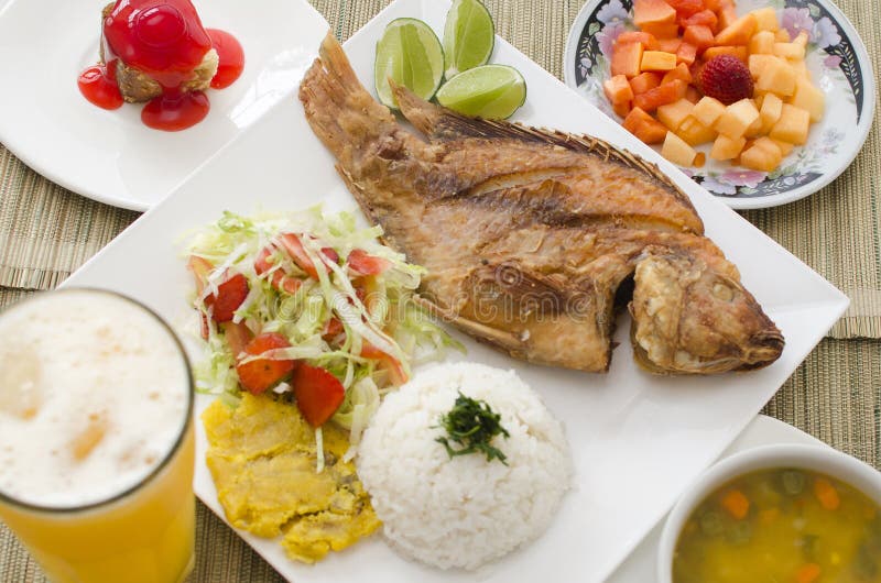 Traditional Fried Fish with Rice, Salad and Fried Plantain Stock Photo ...