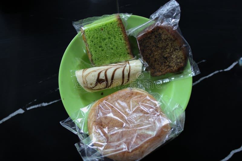 Traditional Indonesian Cakes in Plastic Packaging on Green Plate Stock ...