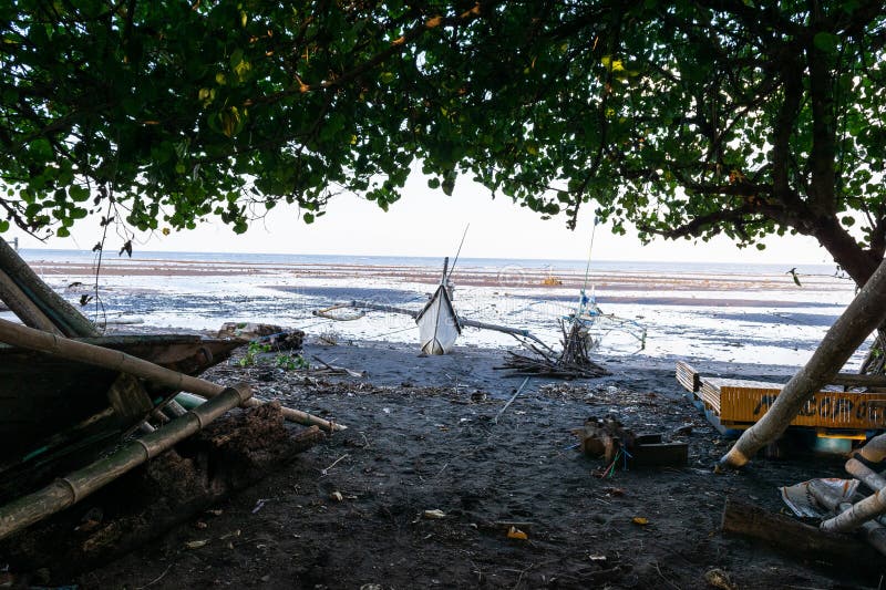 Traditional Indonesian Fishing Boat Resting on Java Beach at Low Tide ...