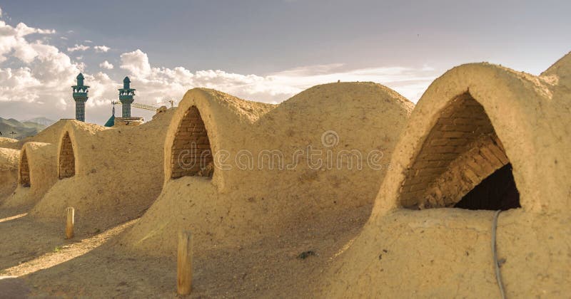 Traditional Mud Brick Structures and Blue Minarets. Stock Image - Image ...
