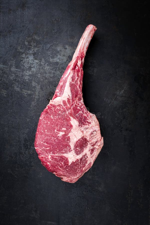 Traditional Raw Dry Aged Angus Tomahawk Steak on an Old Rustic Board ...