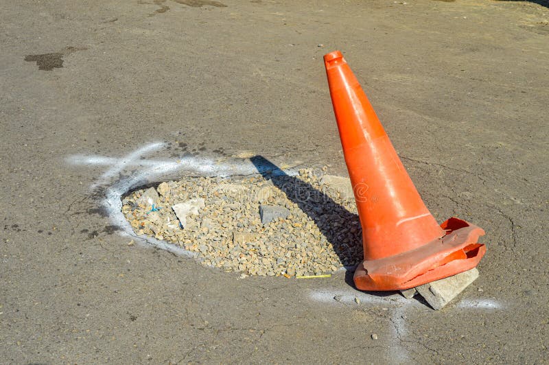 A Traffic Cone Placed Near a Pothole As a Sign Stock Photo - Image of ...