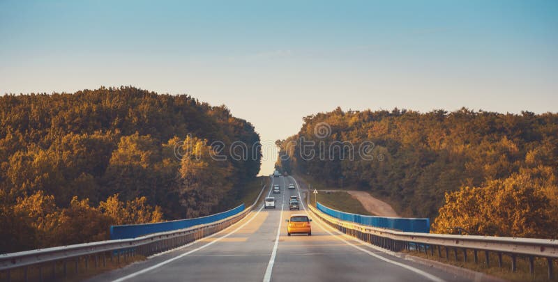 Traffic in High Speed on a Highway through Rural Landscape on Sunset ...