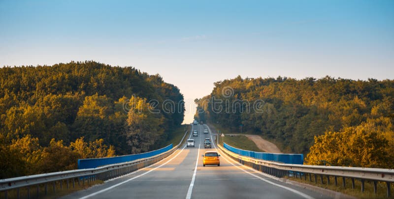 Traffic in High Speed on a Highway through Rural Landscape on Sunset ...