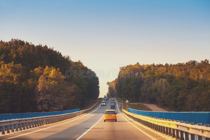 Traffic in High Speed on a Highway through Rural Landscape at Sunset ...