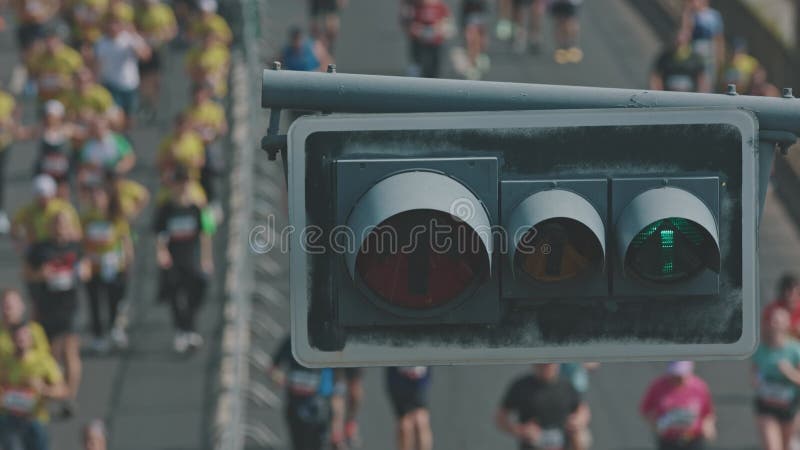 Traffic Light in the Foreground - People Running a Half Marathon on the ...
