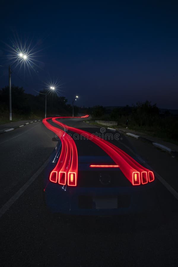 Trail of Lights after a Blue Mustang in the Night Stock Image - Image ...