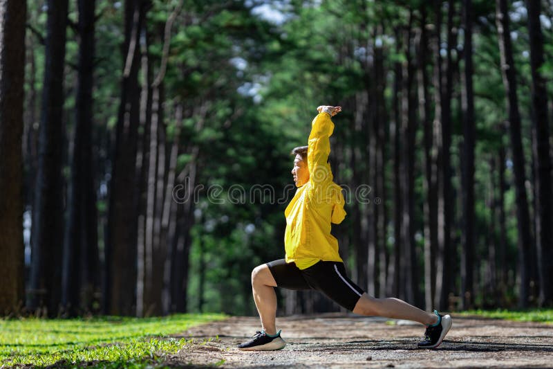 Trail Runner is Stretching for Warm Up Outdoor in the Pine Forest Dirt ...