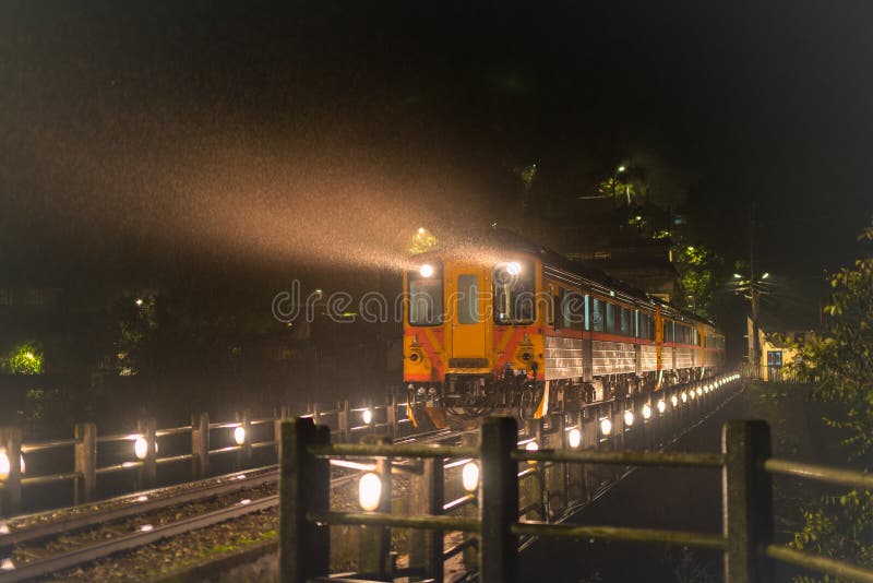 The Train with Lights on Was Running on the Bridge in the Rain ...