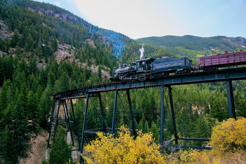 Train Locomotive on Large Metal Bridge into Mountains Covered in Pine ...