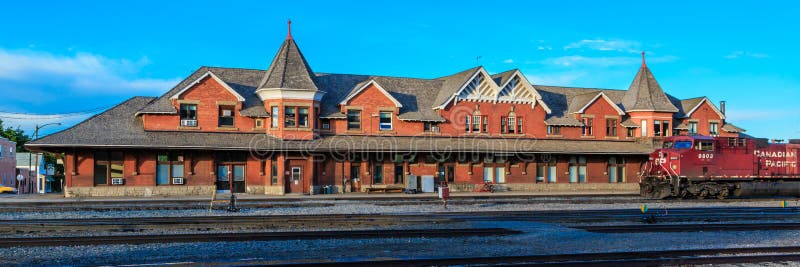 A Train is Parked in Front of a Large Brick Building Editorial Stock ...