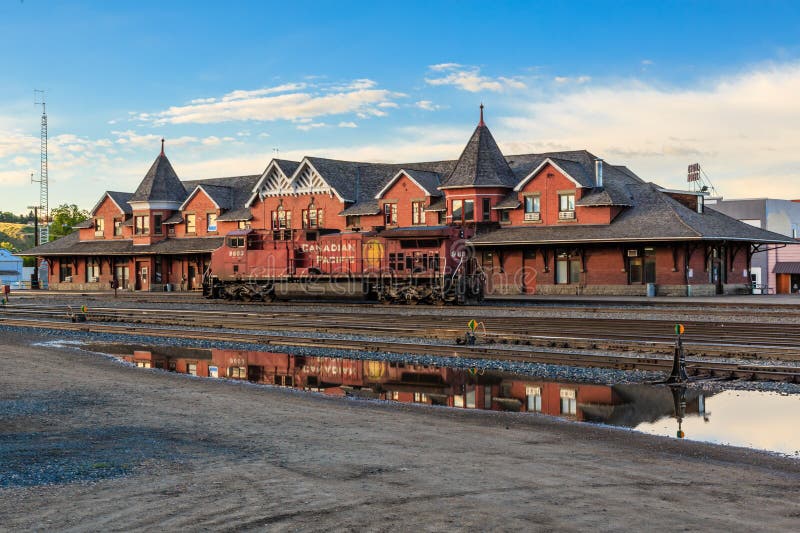 A Train is Parked in Front of a Large Brick Building Stock Photo ...