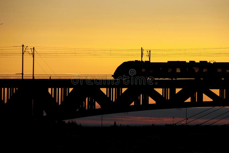 The Train Riding Over the Bridge Over the River at Sunset. Editorial ...