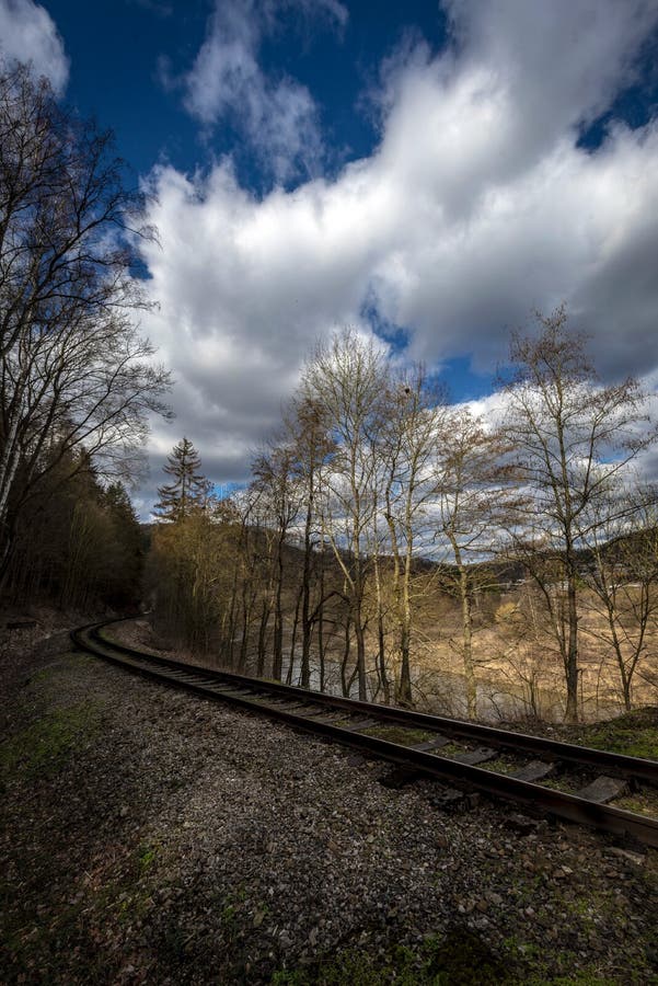 Train Tracks Leading through the Forest and Storm Clouds Stock Image ...