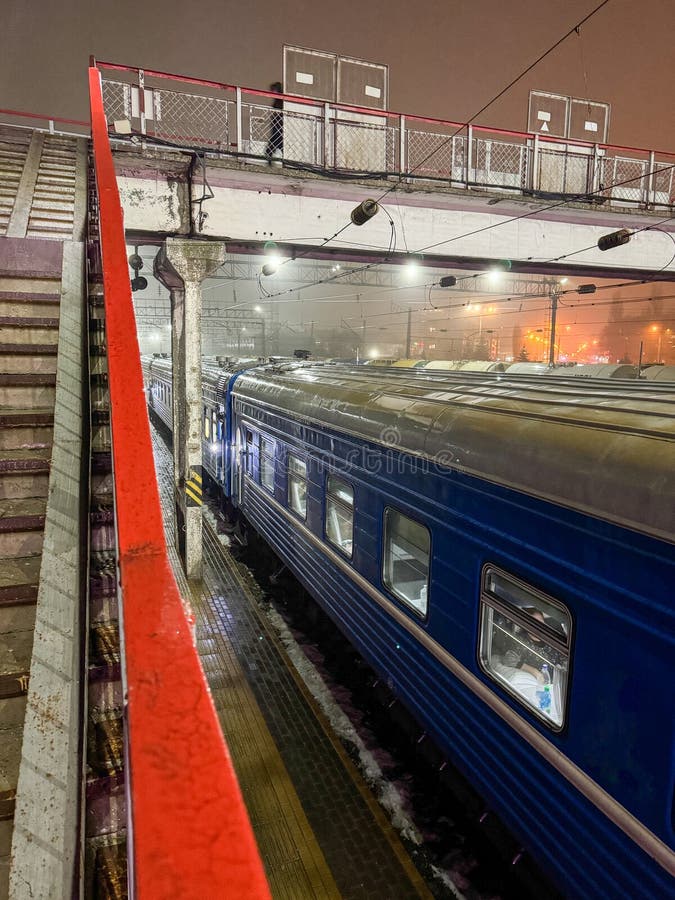 A Train is on the Tracks with a Red Railing in the Background Stock ...