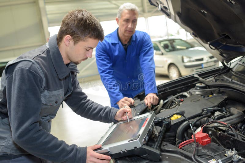 Trainee Testing Car Electronics with Computer in Professional Garage ...