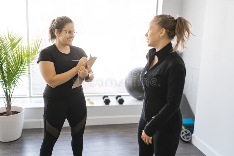 Trainer and Client Discussing Her Progress at the Gym Stock Photo ...