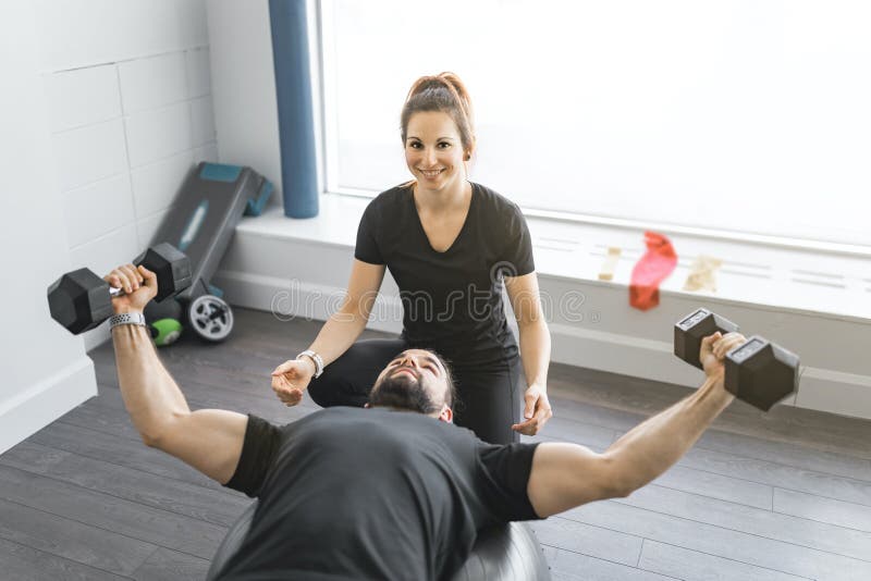 Trainer and Client Discussing Her Progress at the Gym Stock Photo ...
