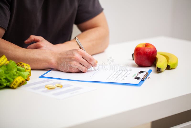 Trainer Draws Up a Training Program and a Healthy Diet Plan. Stock ...