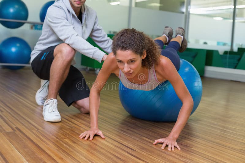 Trainer Helping His Client Doing Push Up on Exercise Ball Stock Image ...