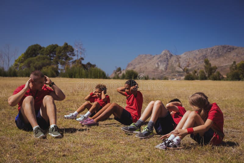 Trainer Instructing Kids while Exercising in the Boot Camp Stock Image ...