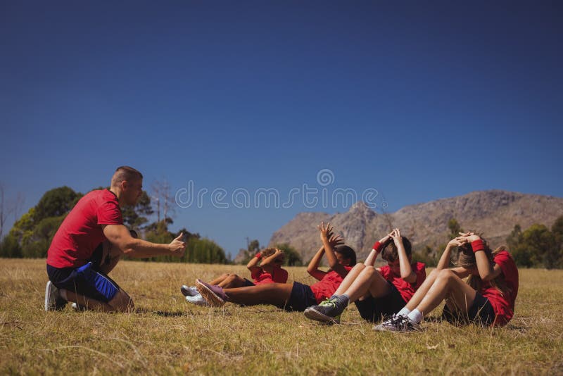 Trainer Instructing Kids while Exercising in the Boot Camp Stock Photo ...