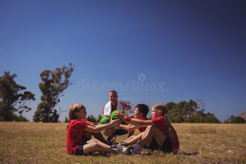 Trainer Instructing Kids while Exercising in the Boot Camp Stock Image ...