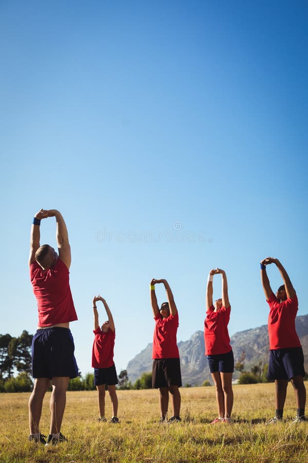 Trainer Instructing Kids while Exercising in the Boot Camp Stock Image ...