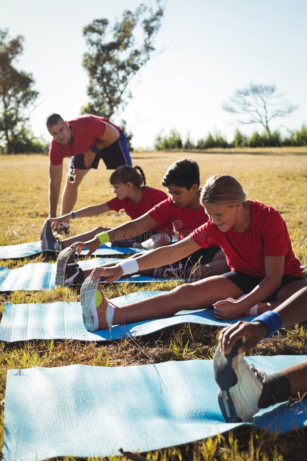 Trainer Instructing Kids while Exercising in the Boot Camp Stock Image ...
