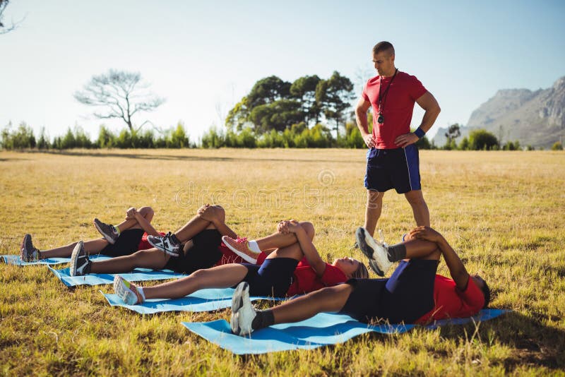 Trainer Instructing Kids while Exercising in the Boot Camp Stock Photo ...