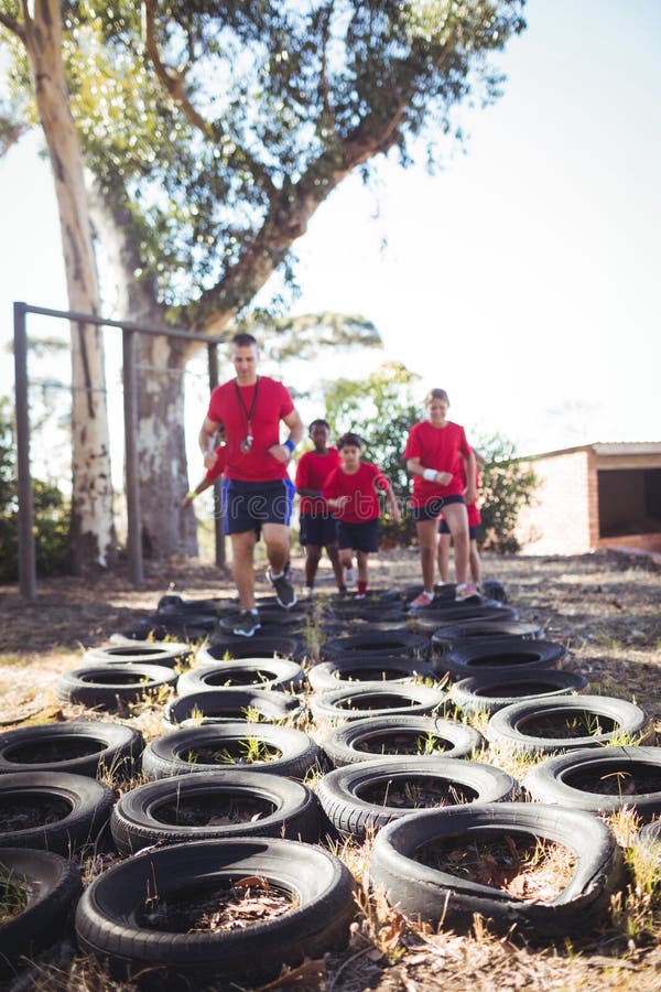 Trainer Instructing Kids during Tyres Obstacle Course Training Stock ...