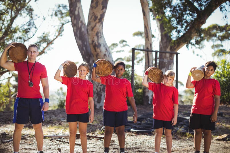 Trainer and Kids Carrying Wooden Logs during Obstacle Course Training ...