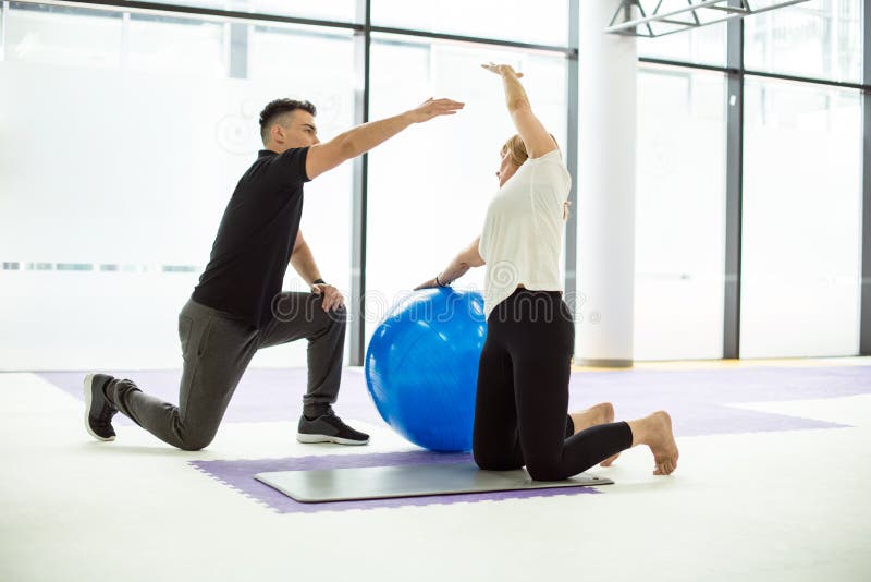 Trainer Show Exercise with Ball To a Senior Woman Stock Photo - Image ...