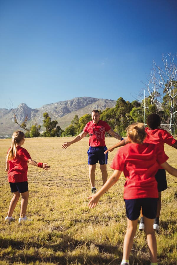 Male Trainer Instructing Kids while Exercising in the Boot Camp Stock ...
